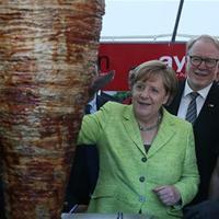 German chancellor Angela Merkel cuts, eats döner kebab in Berlin ...